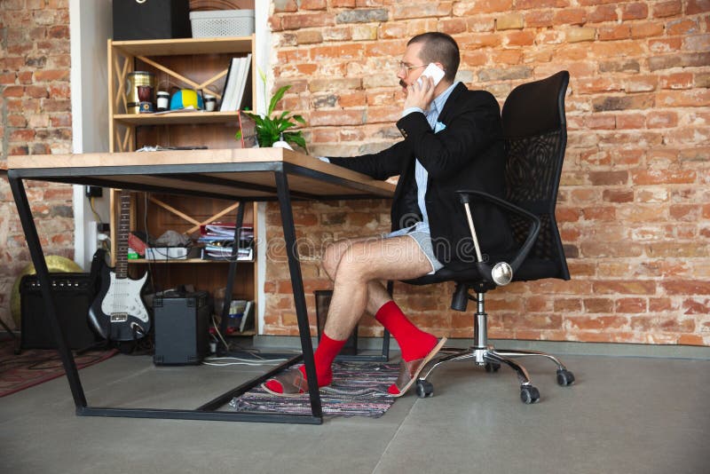 Young Man without Pants but in Jacket Working on a Computer, Laptop ...