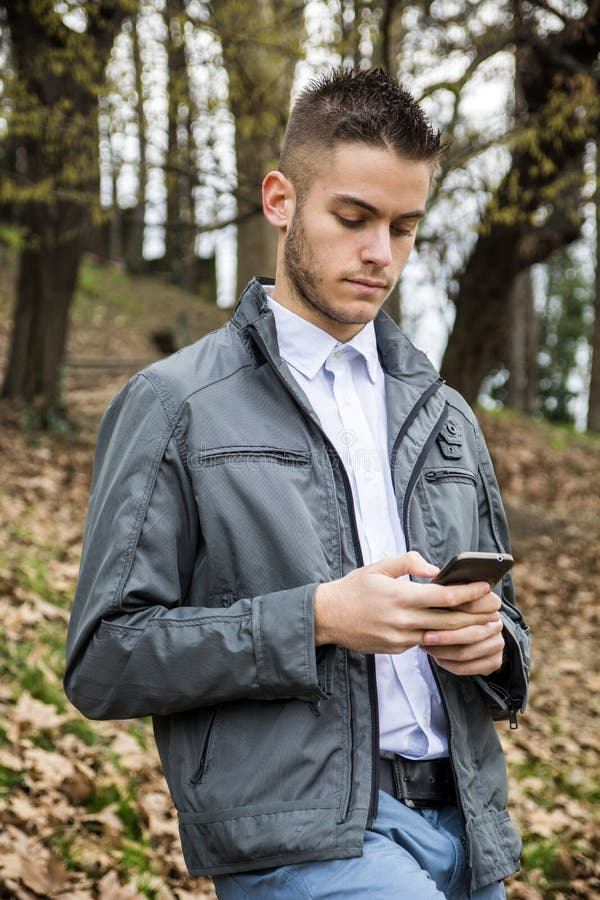 Young Man in Park Using Cell Phone Stock Photo - Image of mobile ...