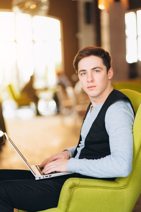 Young Man with Pc Computer Sits in a Comfortable Chair Stock Photo ...