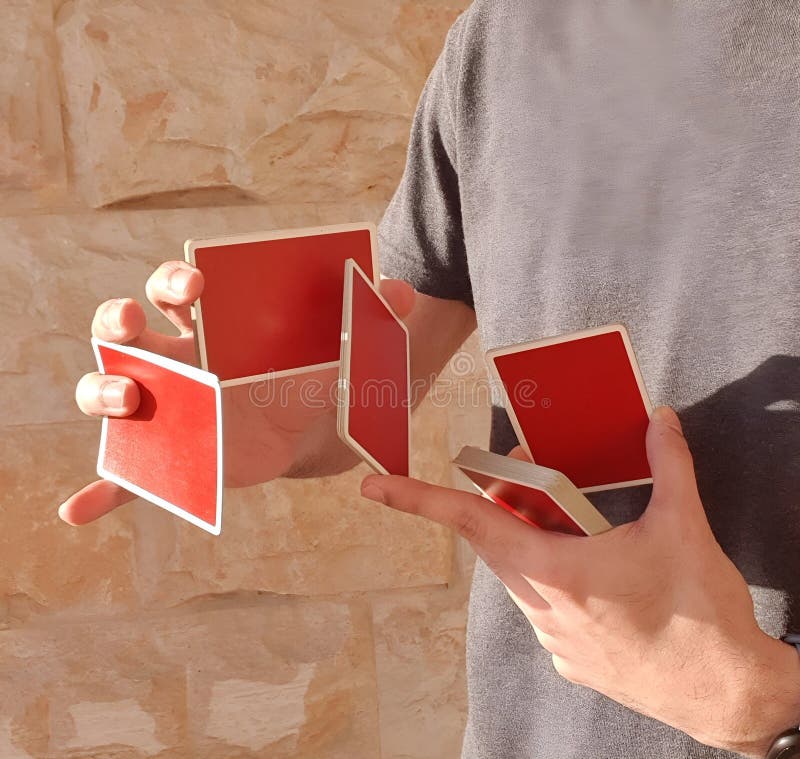 Young Man Performing a Card Trick with a Deck of Red Playing Cards ...