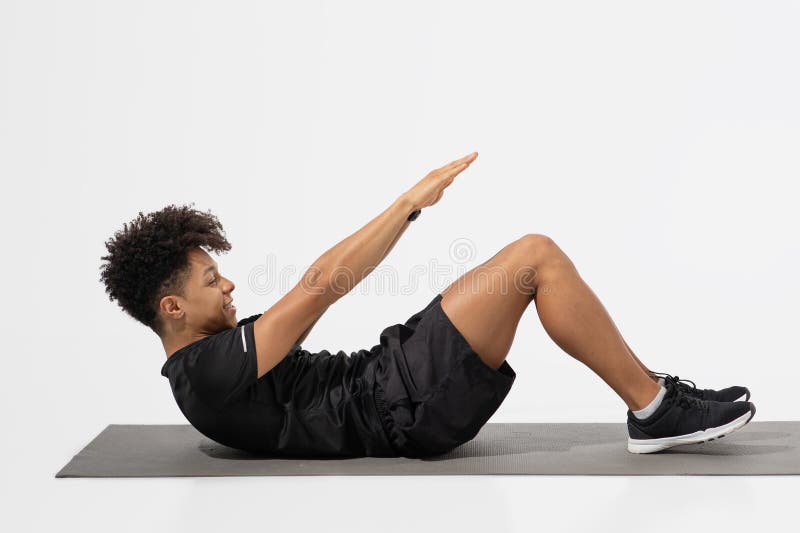 Young Man Performing Core Exercises on Mat in Bright Studio Stock Image ...