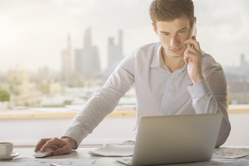 Young Man on Phone Using Laptop Stock Image - Image of business ...