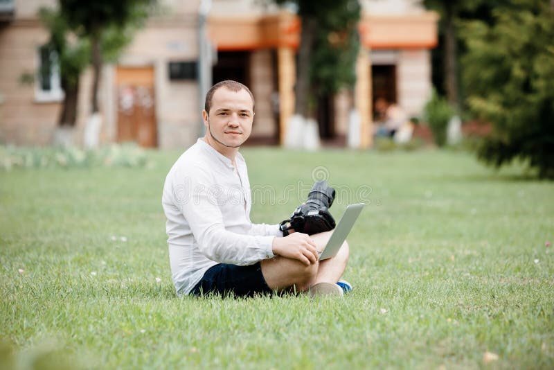 Young Man Photographer Using Laptop and Camera in the Park Stock Photo ...