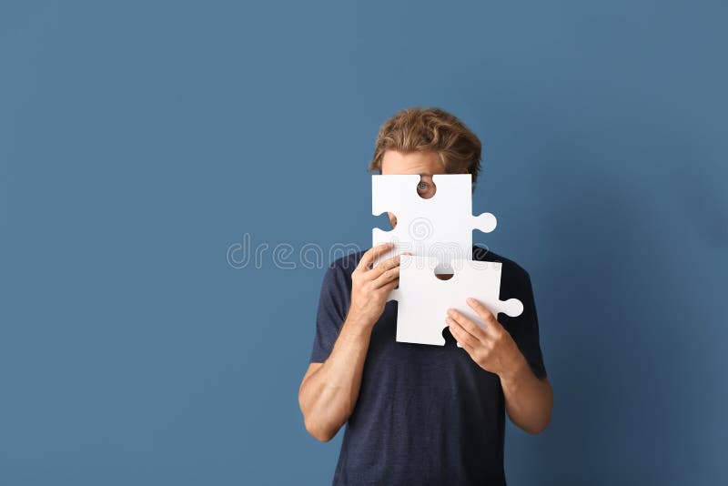 Young Man with Pieces of Jigsaw Puzzle on Color Background Stock Image ...