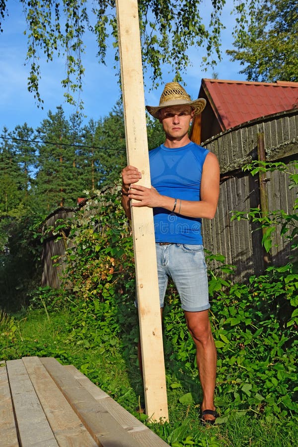 A Young Man with the Pine Board in the Hands of about a Pile of Stock ...