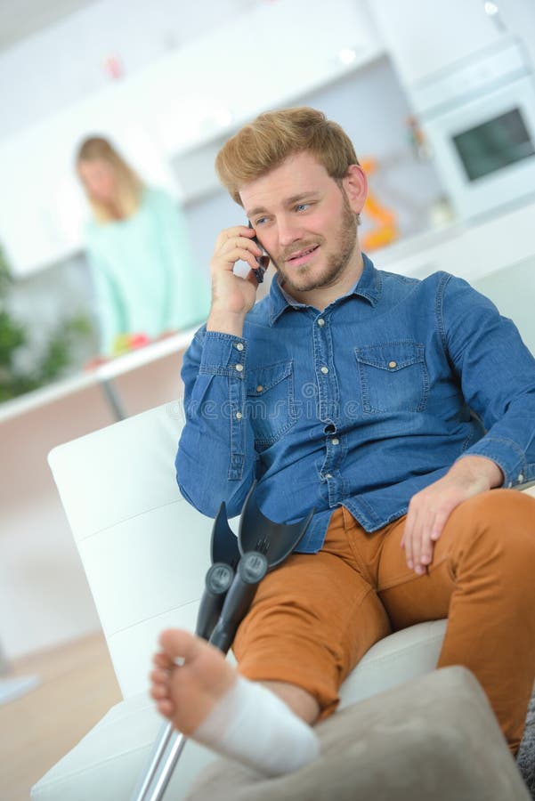 Young Man with Plastered Leg Talking on Mobile Phone Stock Image ...