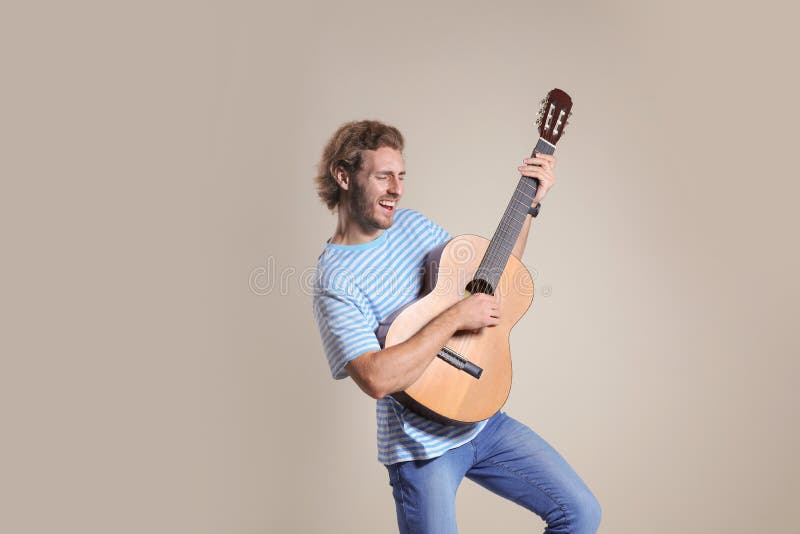 Young Man Playing Acoustic Guitar on Grey Background. Stock Photo ...