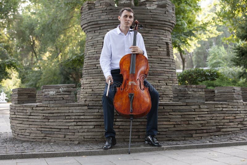 Young Man Playing Cello Outside. Cellist Playing Classical Music on ...