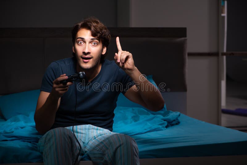 The Young Man Playing Computer Games at Night in Bed Stock Photo ...