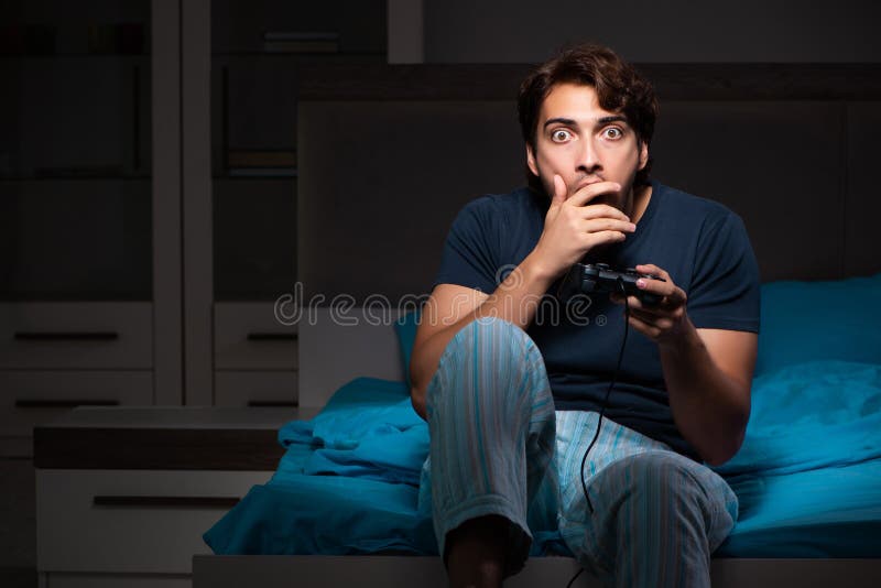 The Young Man Playing Computer Games at Night in Bed Stock Image ...