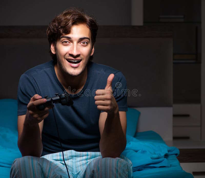 Young Man Playing Computer Games at Night in Bed Stock Photo - Image of ...