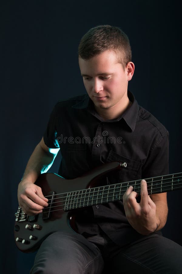 Young Man Playing Electric Bass Guitar Stock Image - Image of backlight ...