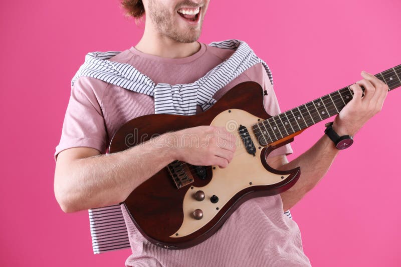 Young Man Playing Electric Guitar on Color Background Stock Image ...