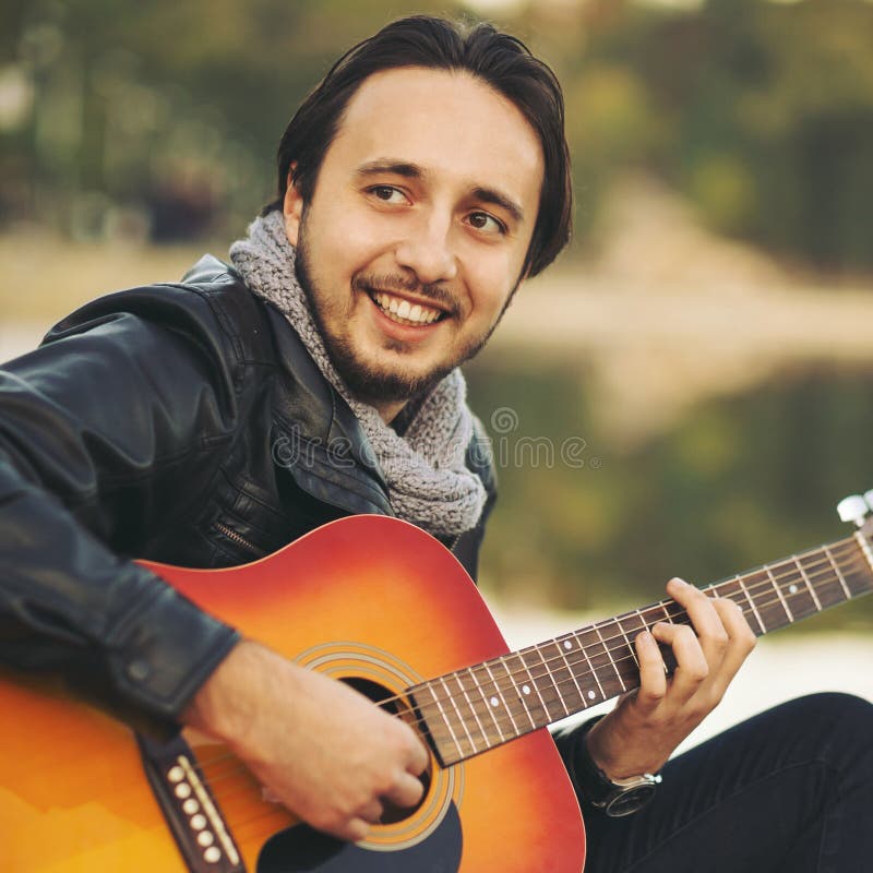 Young Man Playing on Guitar at the Lake Stock Image - Image of autumn ...