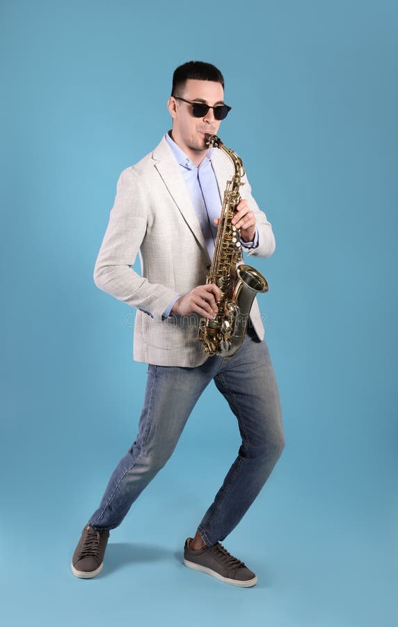 Young Man Playing Saxophone on Light Blue Background Stock Image ...