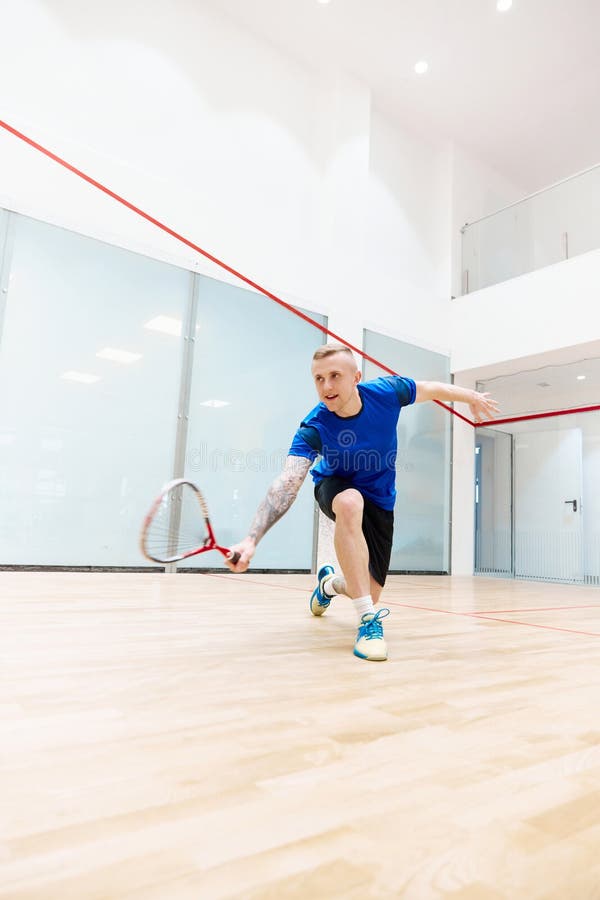 Young Man Playing, Training Squash on Squash Court. Hitting Ball with ...