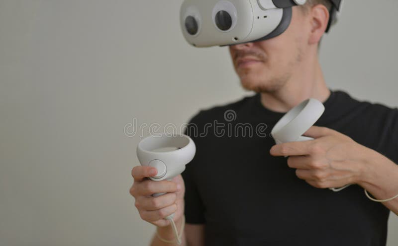 A Young Man Playing Using Visual Reality Glasses with Eye Stickers. VR ...
