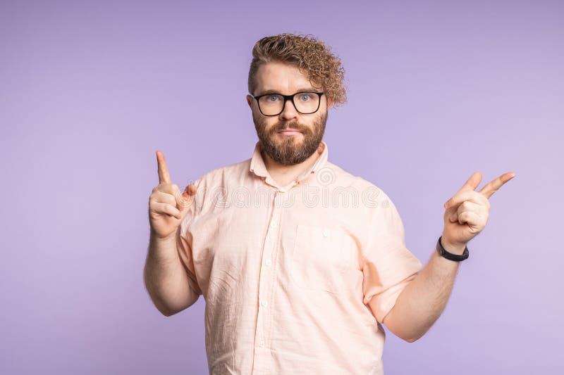 Young Man Pointing Fingers in Opposite Directions with Serious Face ...
