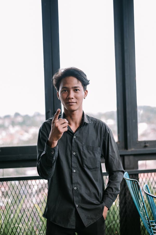 Young Man Points Up in Modern Setting, Expressing an Idea or Concept ...