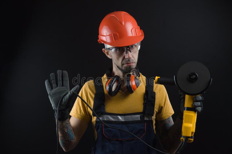 A Young Man Posing on a Black Background in a Work Uniform and a ...