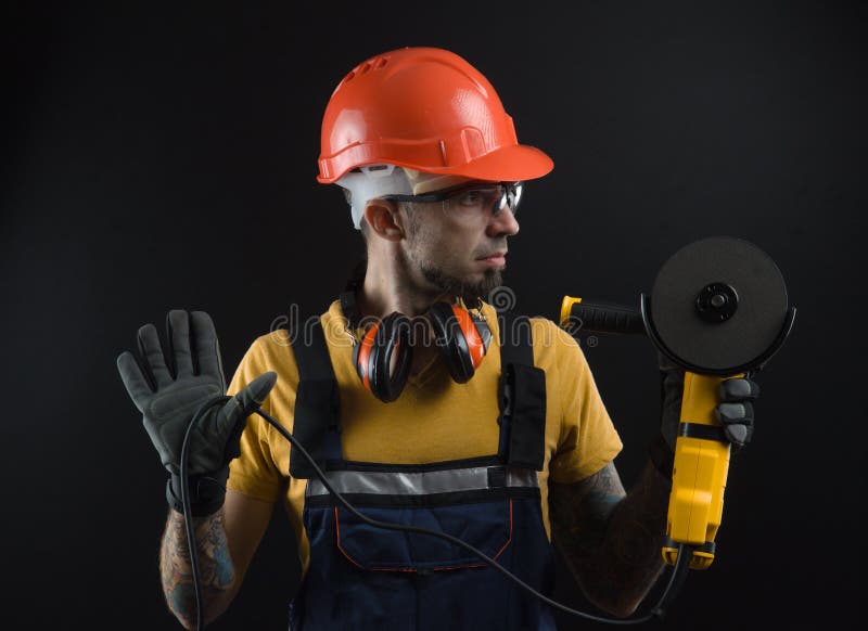 A Young Man Posing on a Black Background in a Work Uniform and a ...