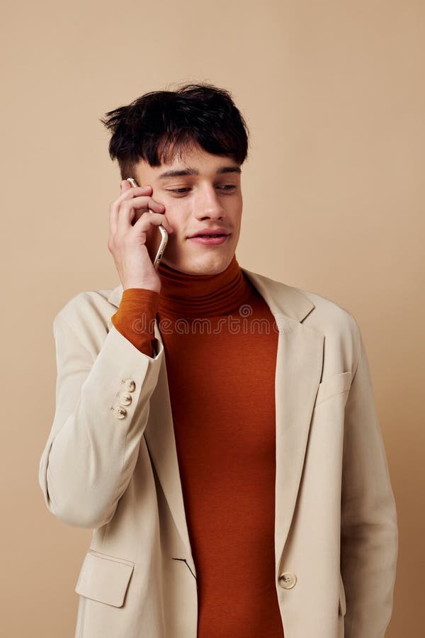 A Young Man Posing with a Phone in His Hands in a Jacket Elegant Style ...