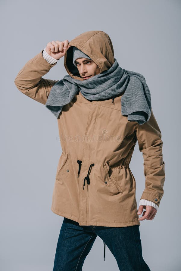 Young Man Posing in Scarf, Coat and Hood, Isolated on Grey Stock Photo ...