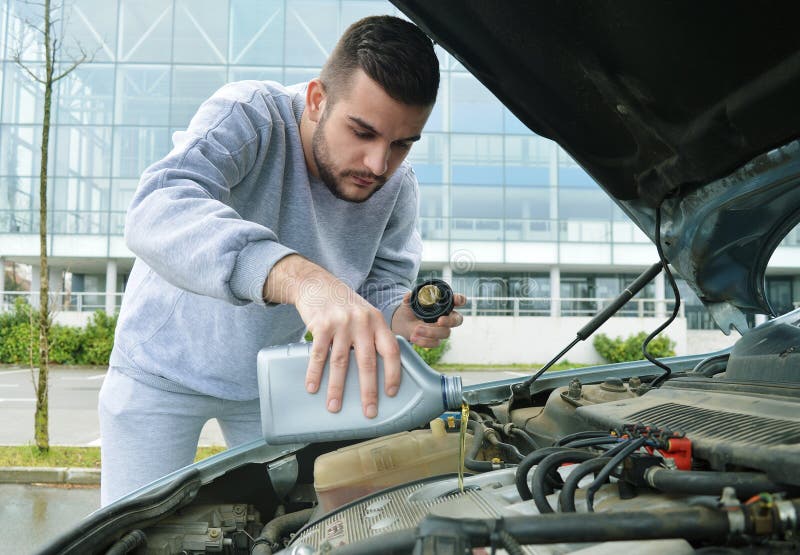 Young Man Pouring Oil into the Car. Stock Photo - Image of pouring ...