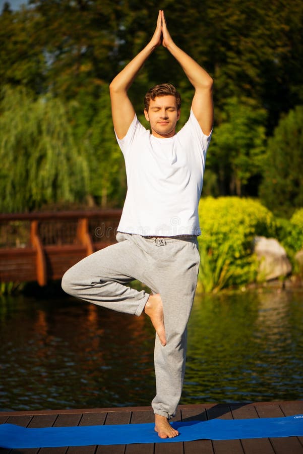 Young Man Practicing Yoga, Doing Tree Pose Stock Image - Image of hand ...