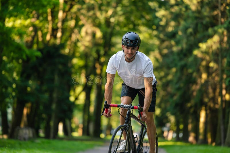 Young Man in Protective Hemlet on a Bike in the Park Stock Photo ...