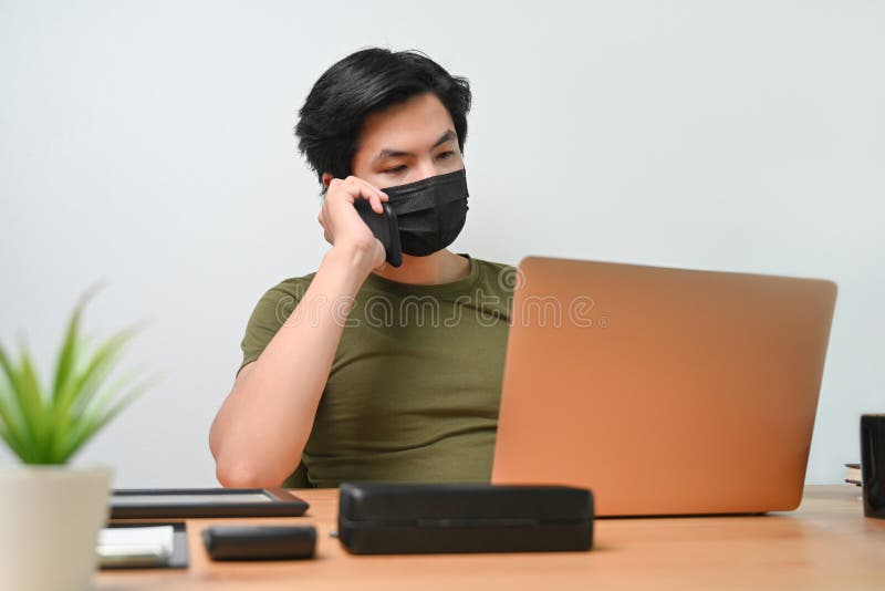 Man in Protective Mask Using Laptop Computer in Coffee Shop. Stock ...