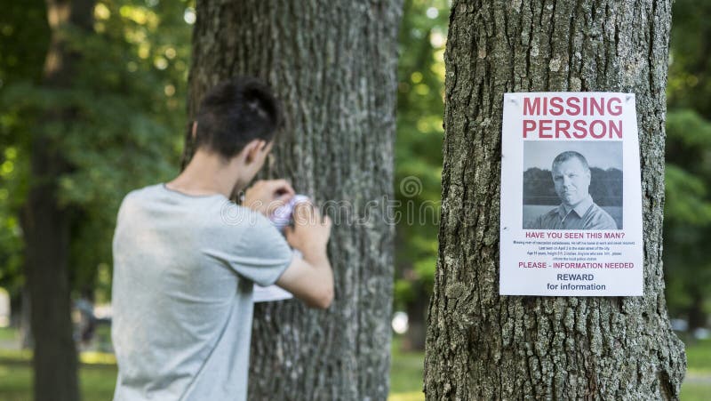 A Young Man Puts Up Ads for a Missing Person in the Park Stock Image ...