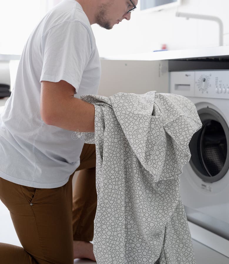 Young Man Putting Clothes into Washing Machine Stock Image - Image of ...