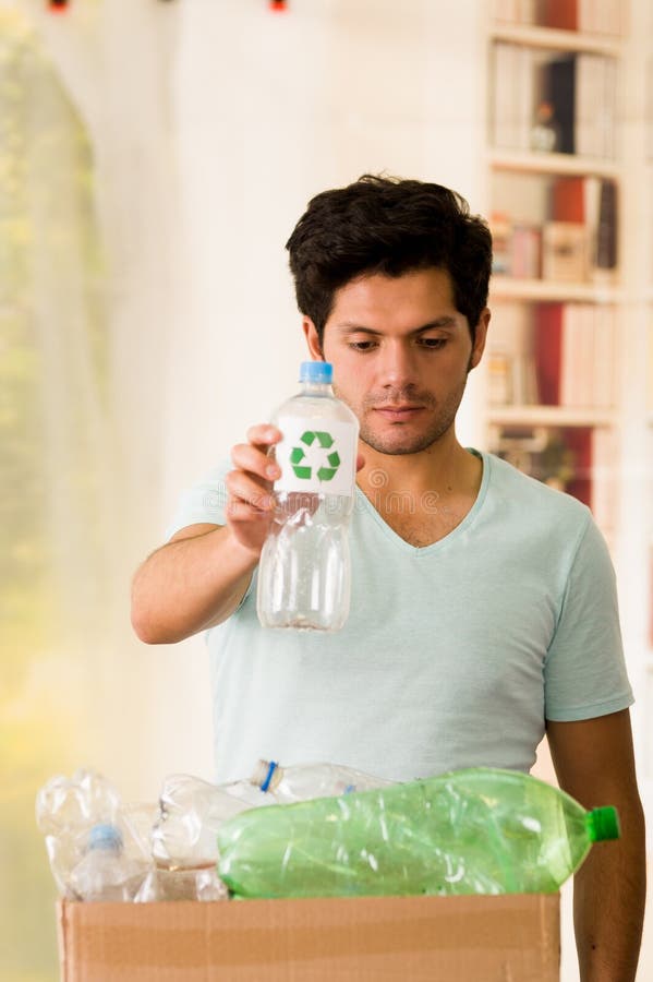 Young Man Putting a Plastic Bottle Inside of a Cardboard Box Full of ...