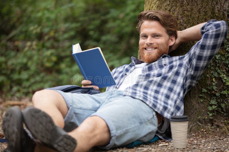 Young Man Read Book Leaning Against Tree Relaxing Stock Photo - Image ...