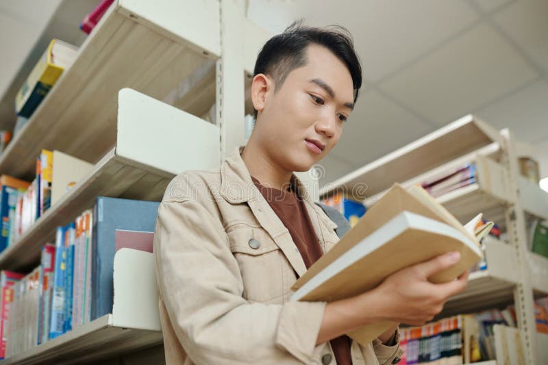 Young Man Reading Book stock image. Image of bookshelf - 271278775
