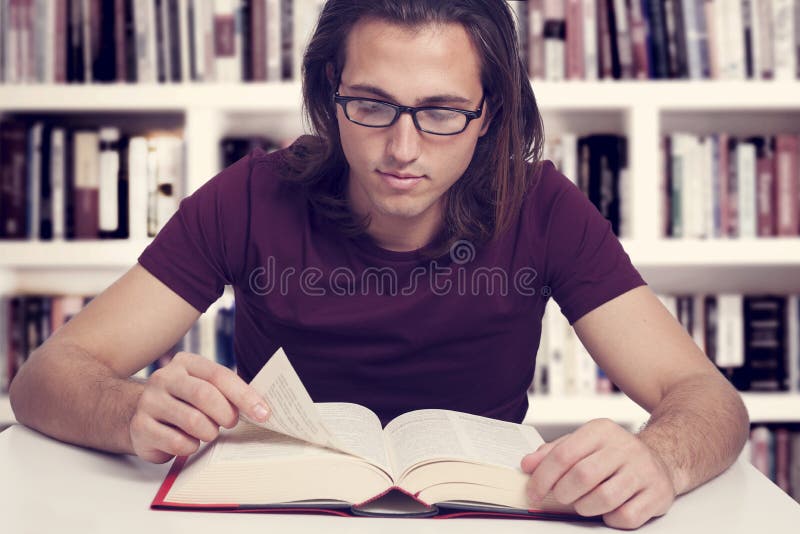 Young Man Reading Book in Library Stock Photo - Image of person ...