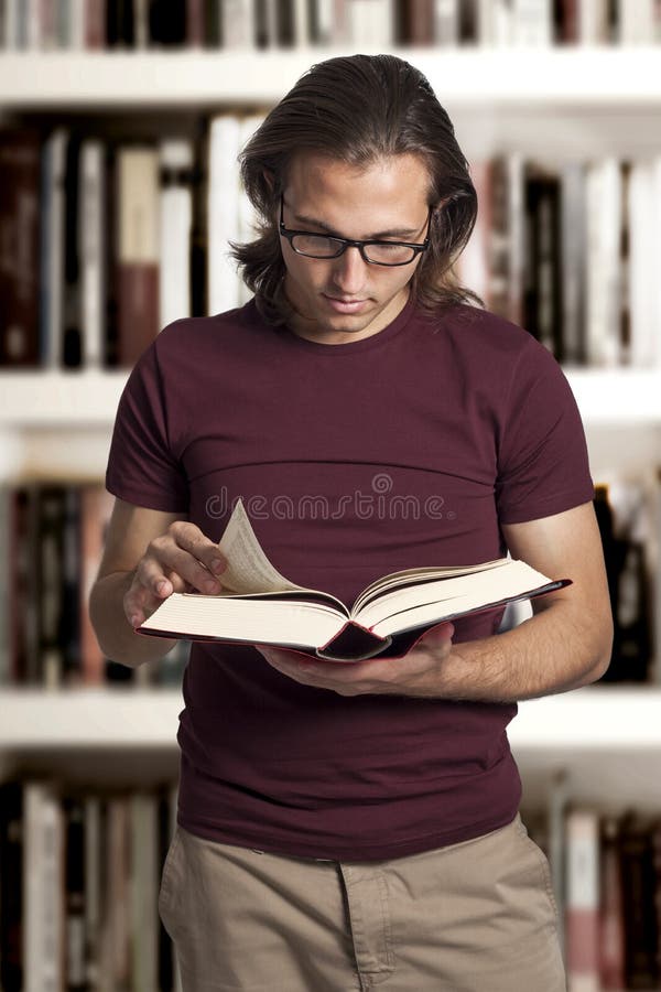 Young Man Reading Book in Library Stock Image - Image of teen, exam ...