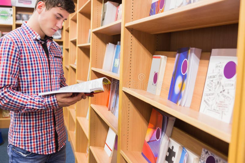 Young Man Reading Book in Library Stock Image - Image of casual ...