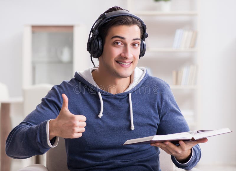 Young Man Reading Book and Listening To Audio Book Stock Image - Image ...