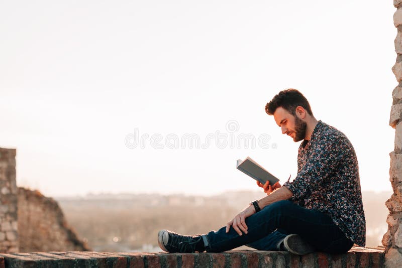 Young Man Reading a Book Outdoors Stock Image - Image of park, hobby ...