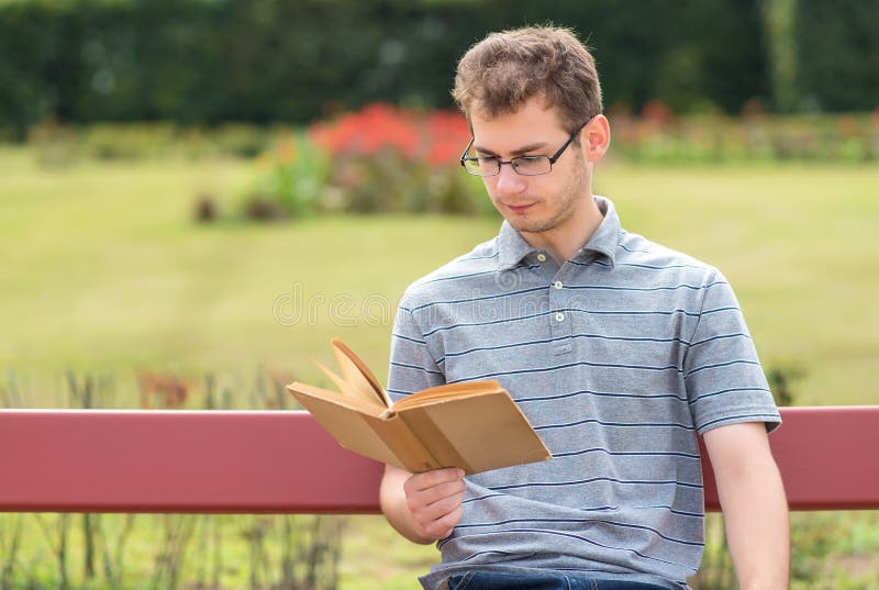 Young Man Reading a Book in Park Stock Photo - Image of brown, studying ...