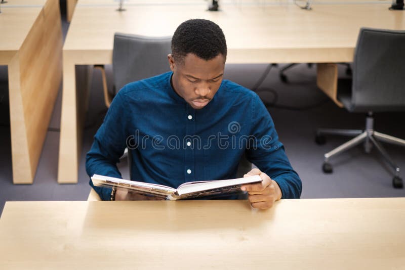 Young Man Reading Book in Public Library Stock Photo - Image of ...