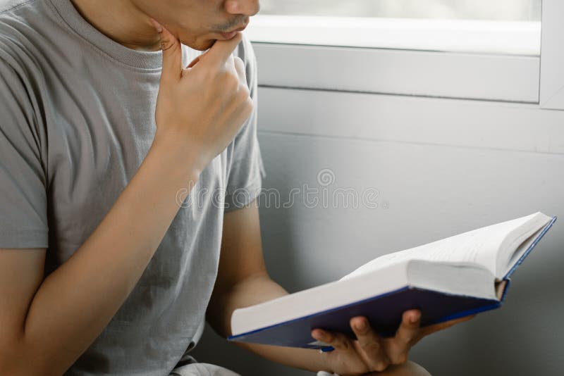 Young Man Reading Book and Thinking Gesture at Living Room in Free Time ...