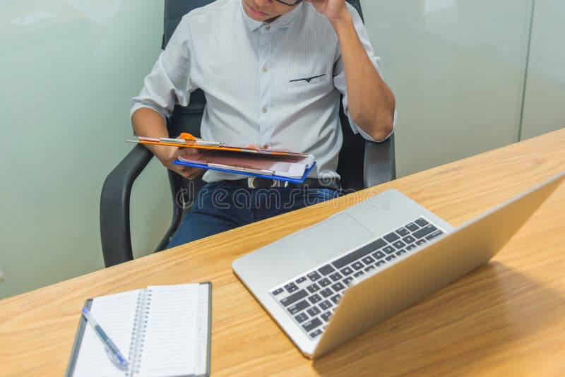 Young Man Reading Finance Document Report in Office Stock Image - Image ...