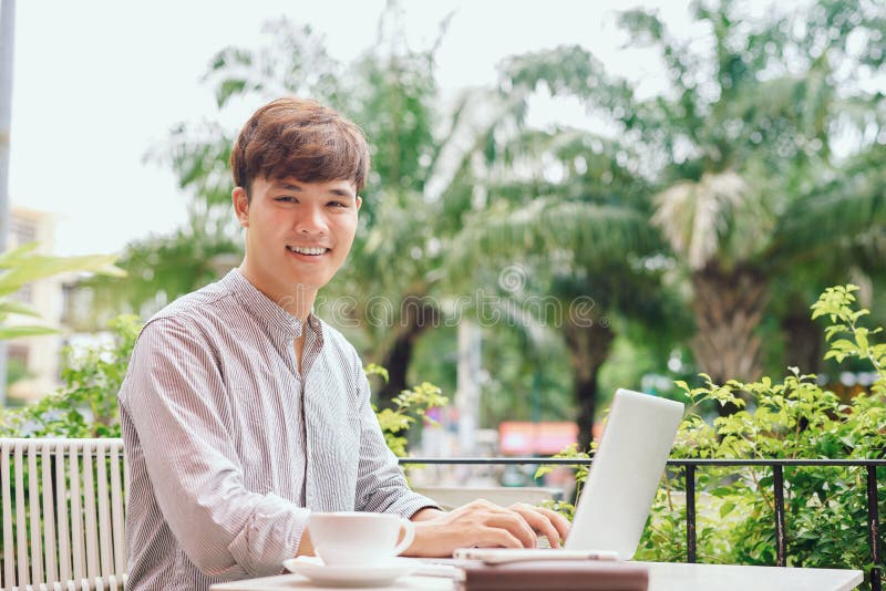 Young Man Reading Information on Smartphone when Working in Cafe Stock ...