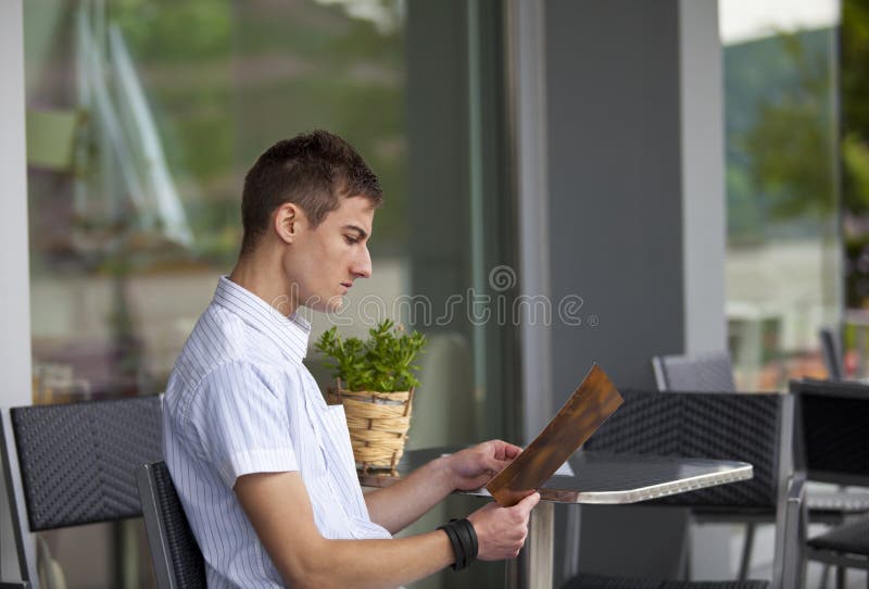 Young man reading the menu stock photo. Image of lifestyle - 20742470