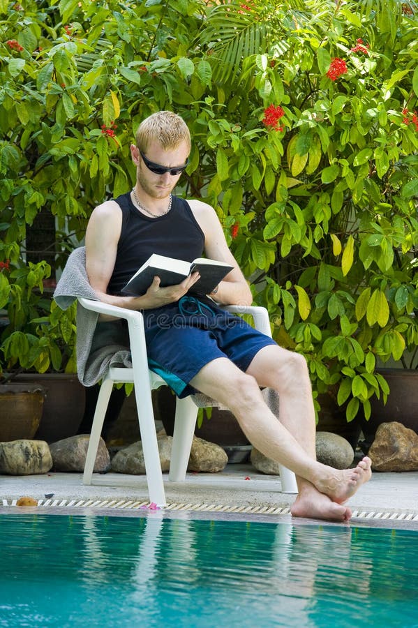 Young Man Reading Nearby the Swimming Pool Stock Photo - Image of ...
