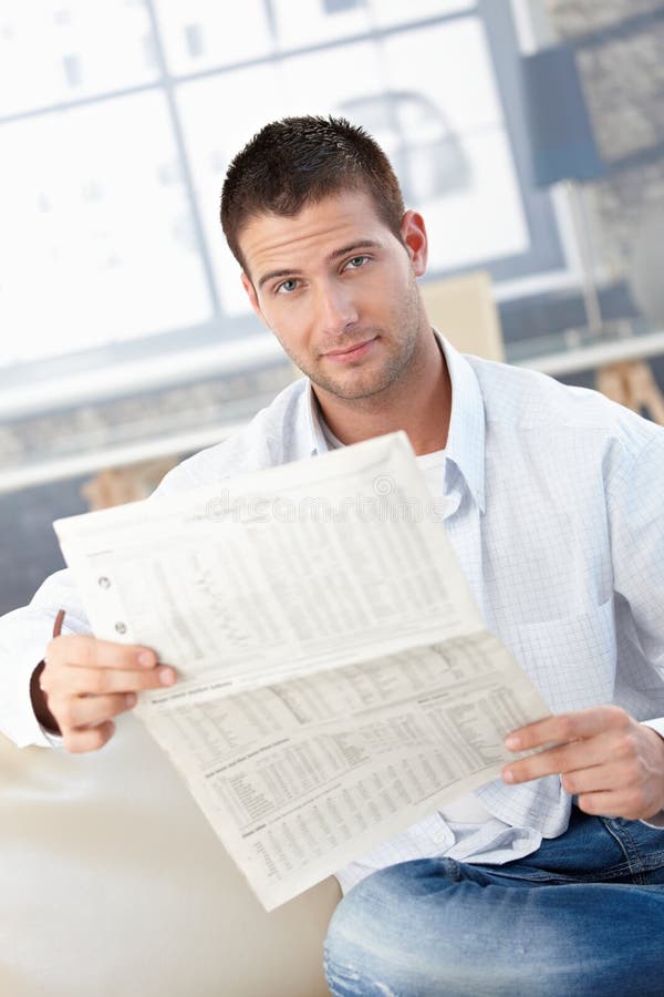 Young Man Reading Newspaper on Sofa Stock Photo - Image of clothing ...