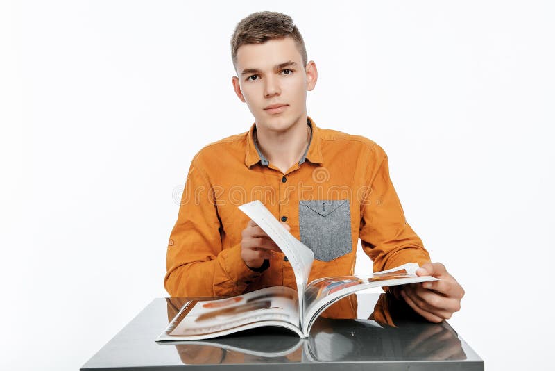 A Young Man Reads a Book. the Guy is Browsing the Magazine. Reading ...